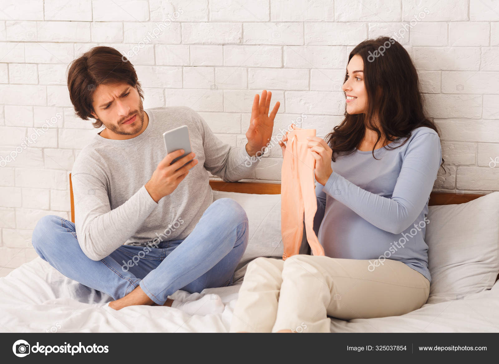 Indifferent husband ignoring his pregnant wife, using smartphone in ...