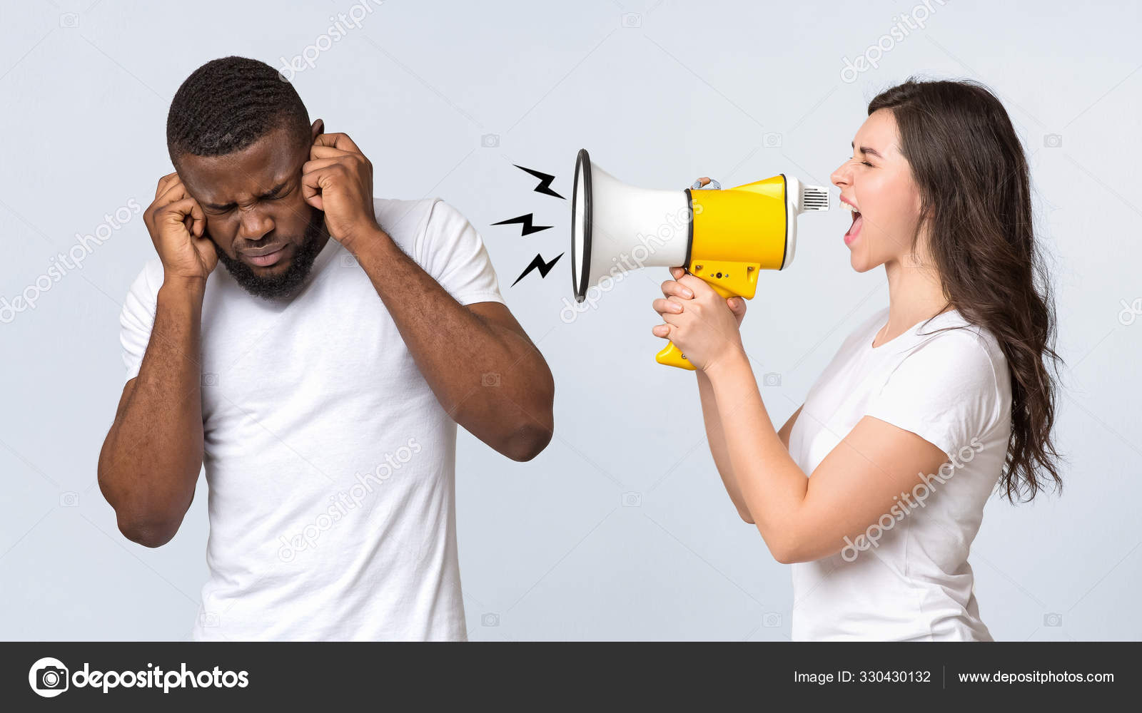 Angry woman shouting at her boyfriend with loudspeaker over light ...