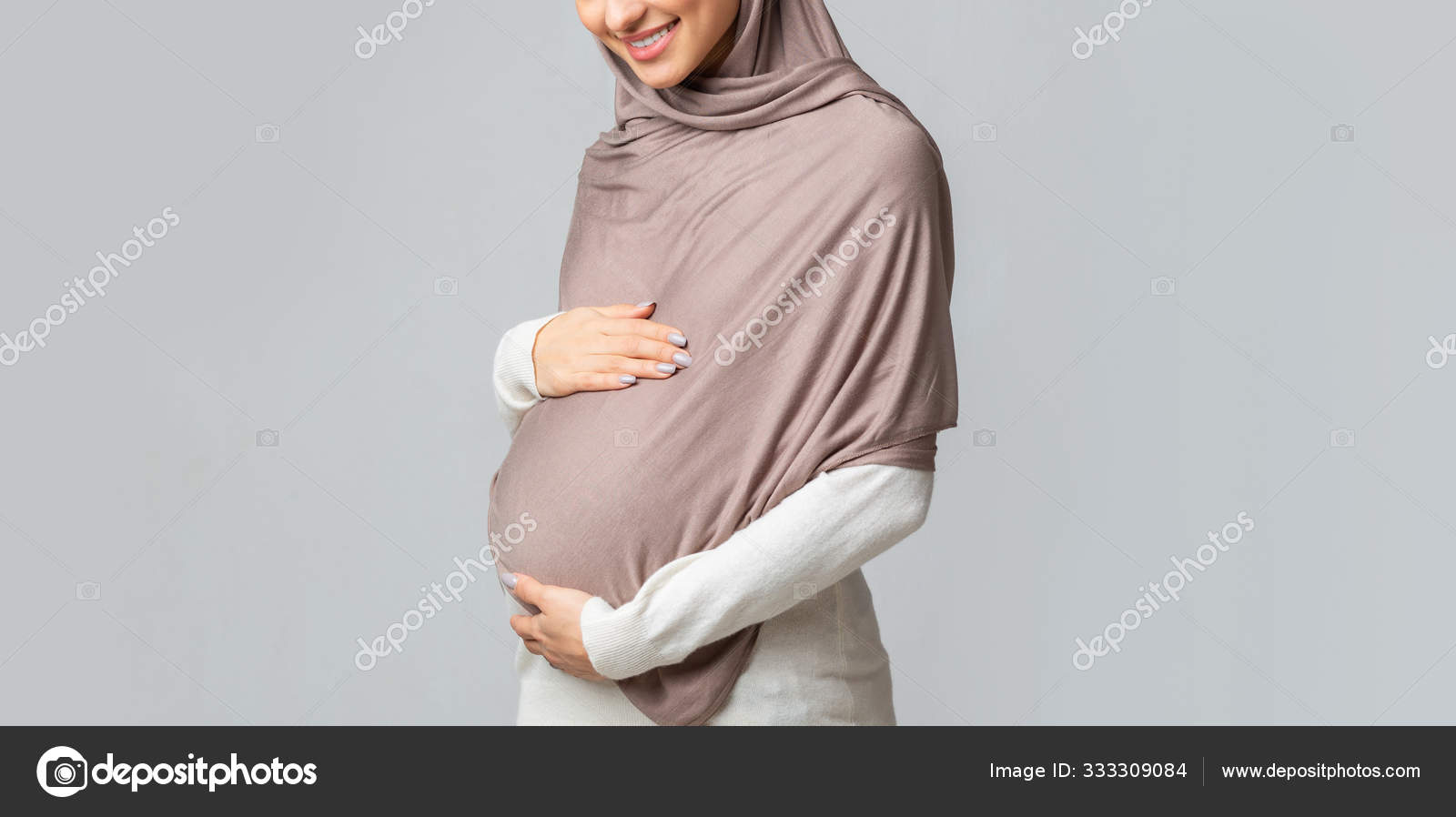 Unrecognizable Pregnant Islamic Woman In Hijab Touching Her Belly Stock