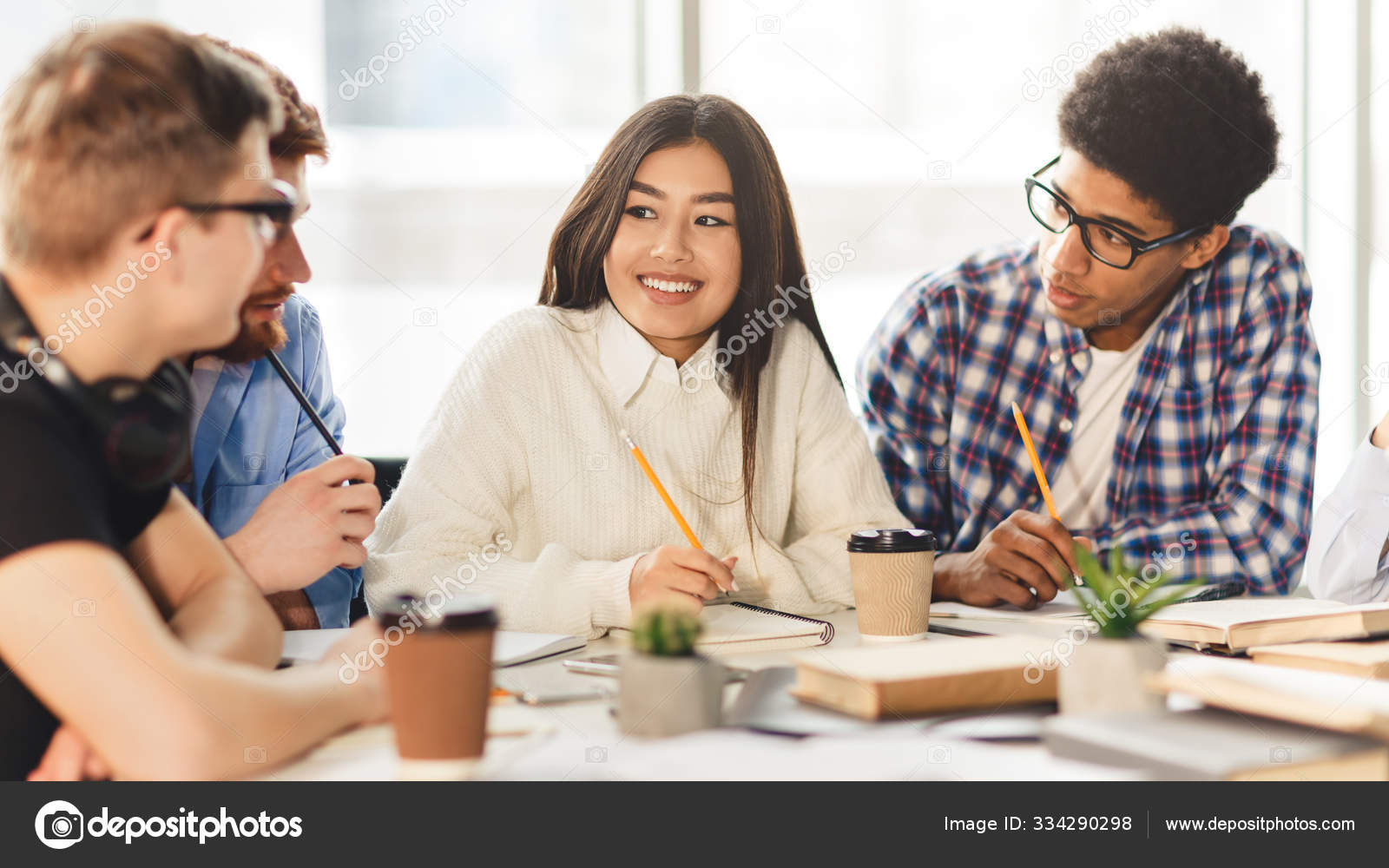 Happy multiracial college students studying with books in library Stock ...