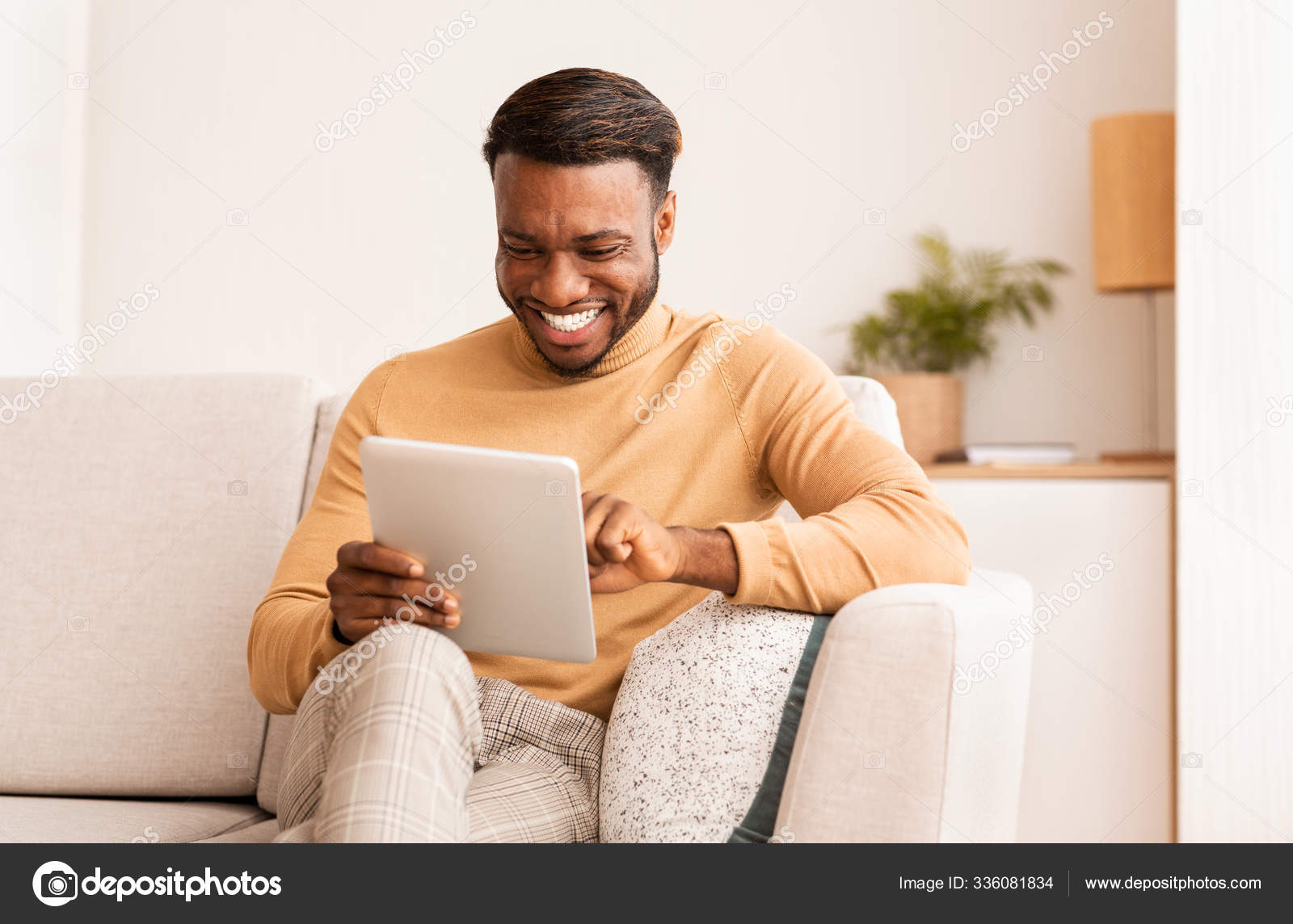 Smiling Guy Using Tablet Enjoying Weekend Sitting On Couch Indoor ...