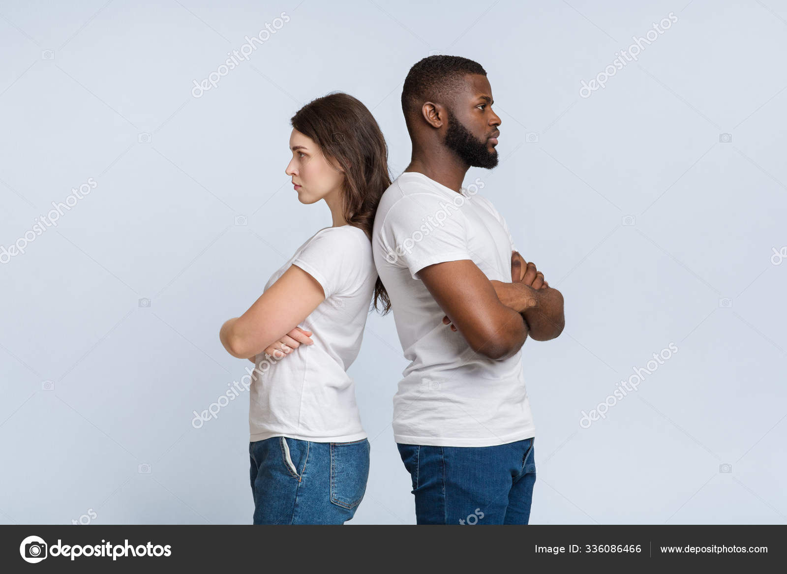 Multiracial couple standing back to back, ignoring each other after ...