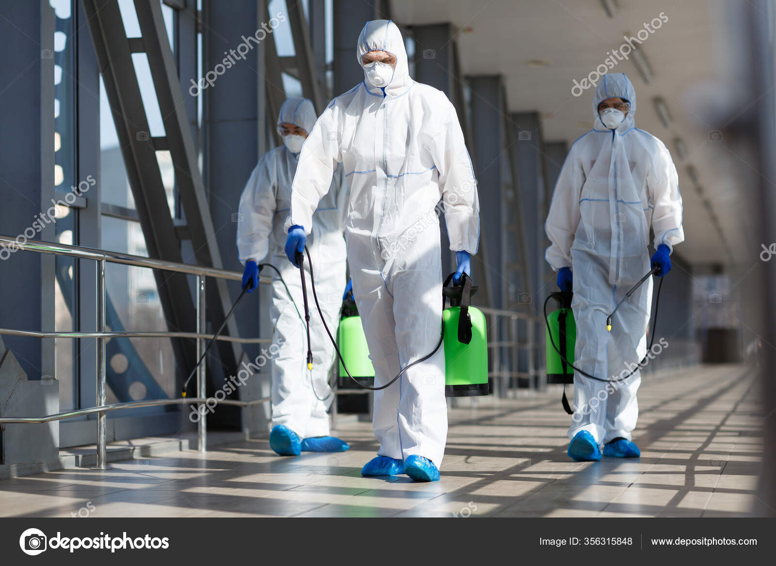 People in virus protective suits and mask disinfecting buildings ...