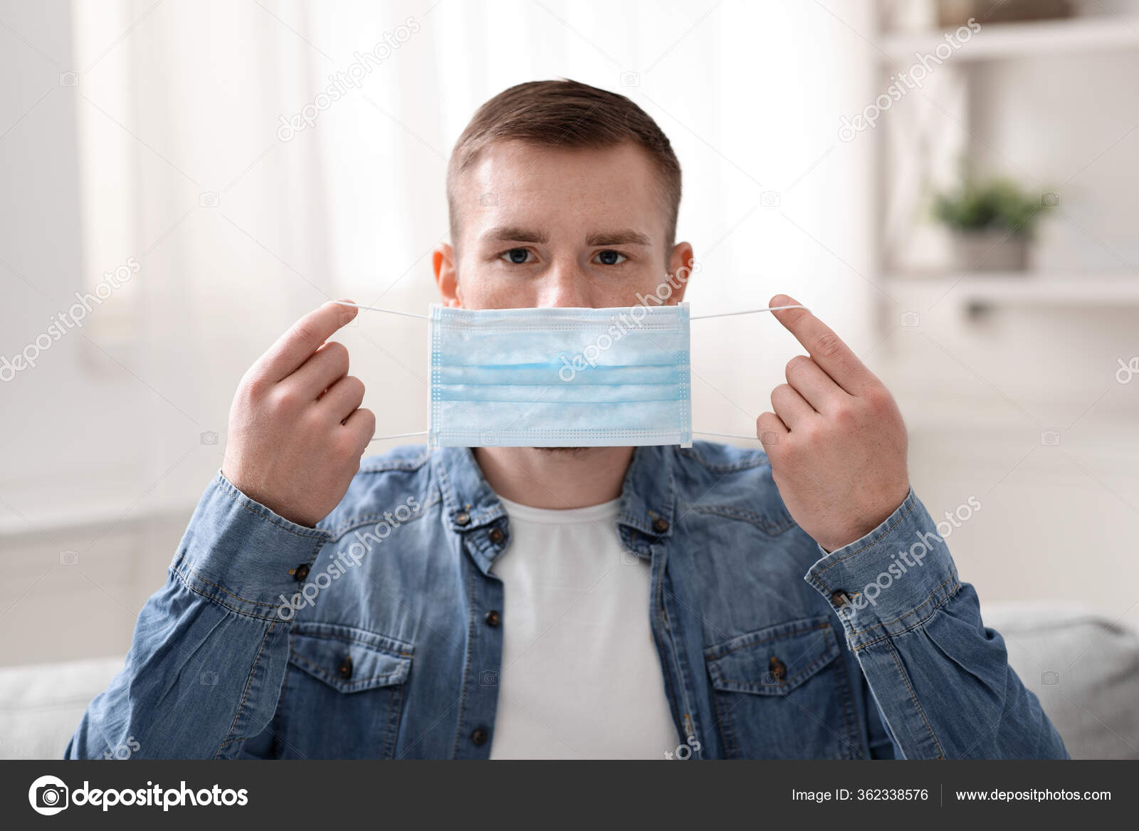 Responsible guy putting on medical protective mask Stock Photo by ...