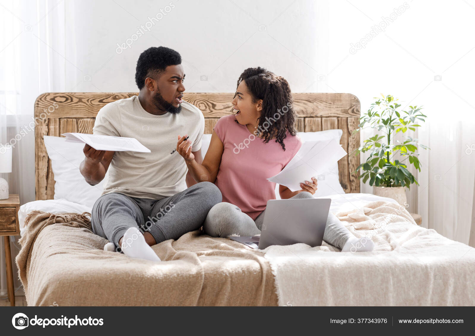 Married couple arguing while checking finances in bedroom Stock Photo ...