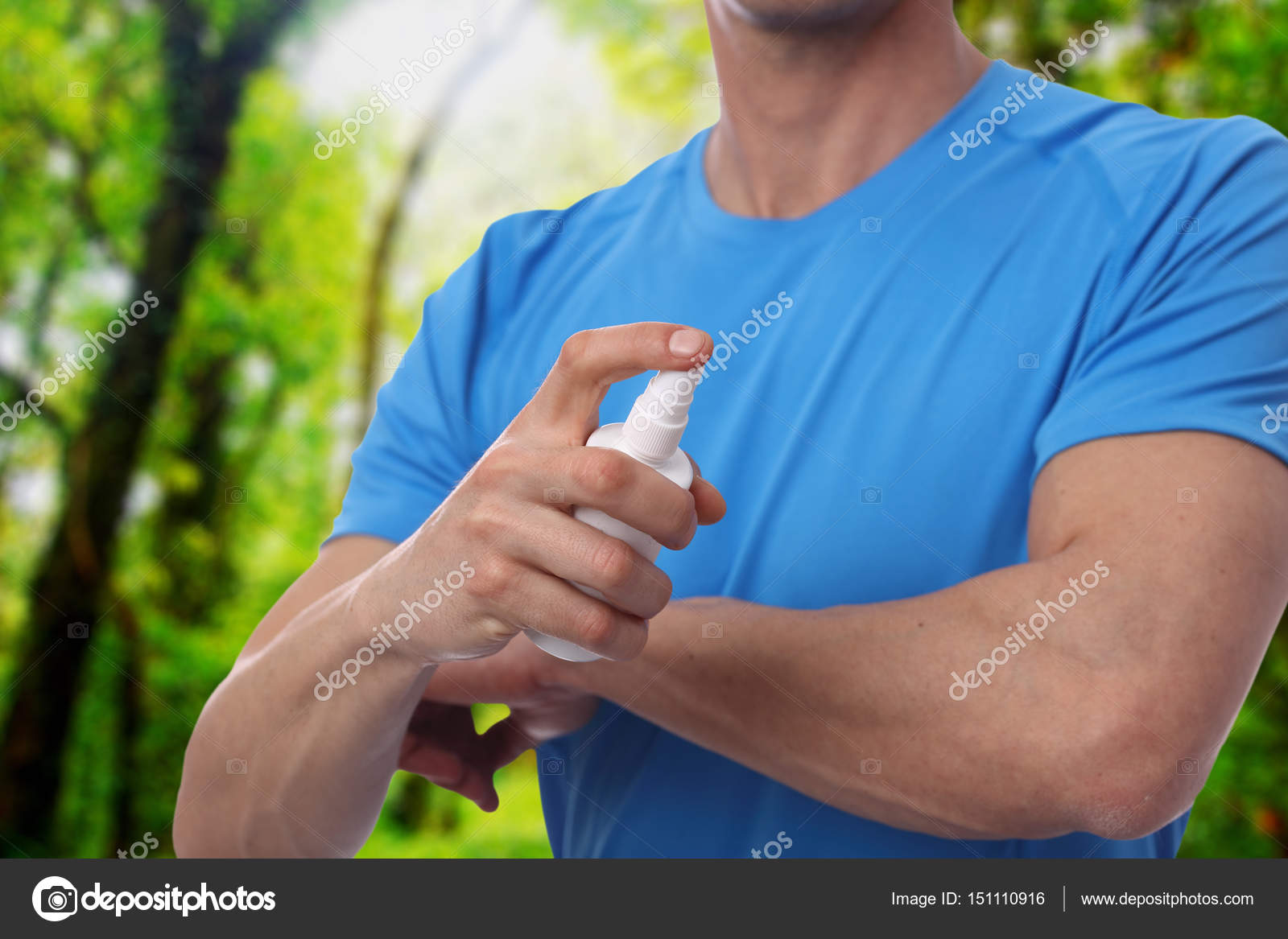 Mosquito repellent. Male using insect repellent spray from bootle in ...