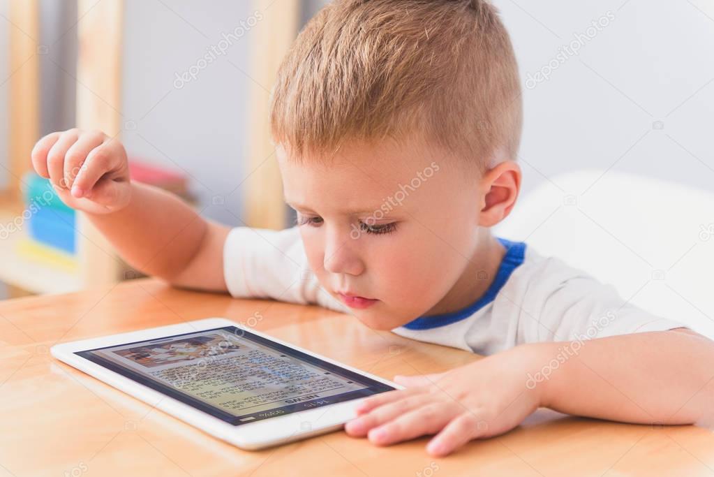 Cute little boy using digital tablet Stock Photo by ©iakovenko123 130160266