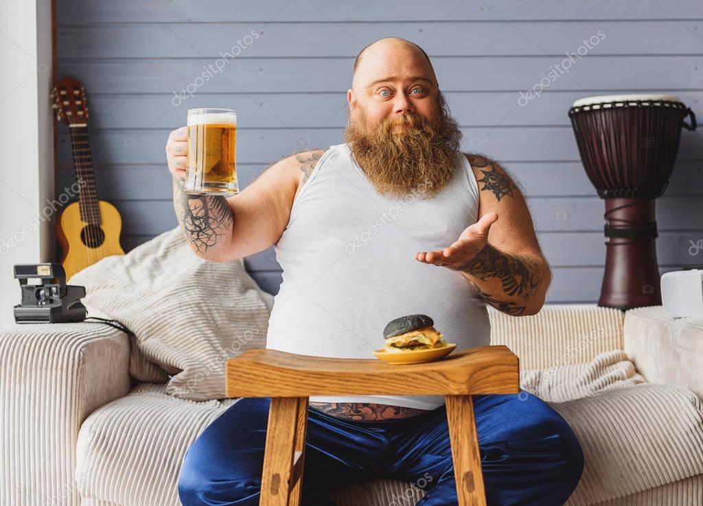 Male fatso drinking beer at home — Stock Photo © iakovenko123 #136846128