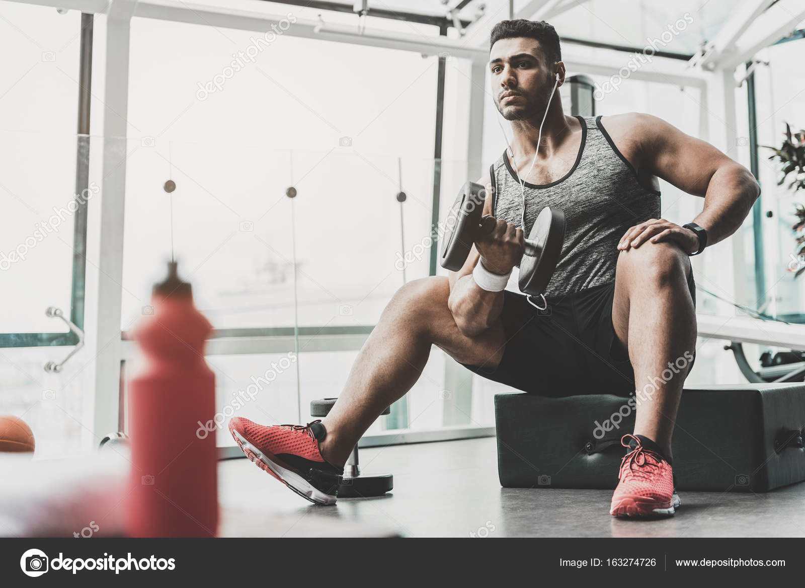 Serious man taking exercise with equipment Stock Photo by ©iakovenko123 ...