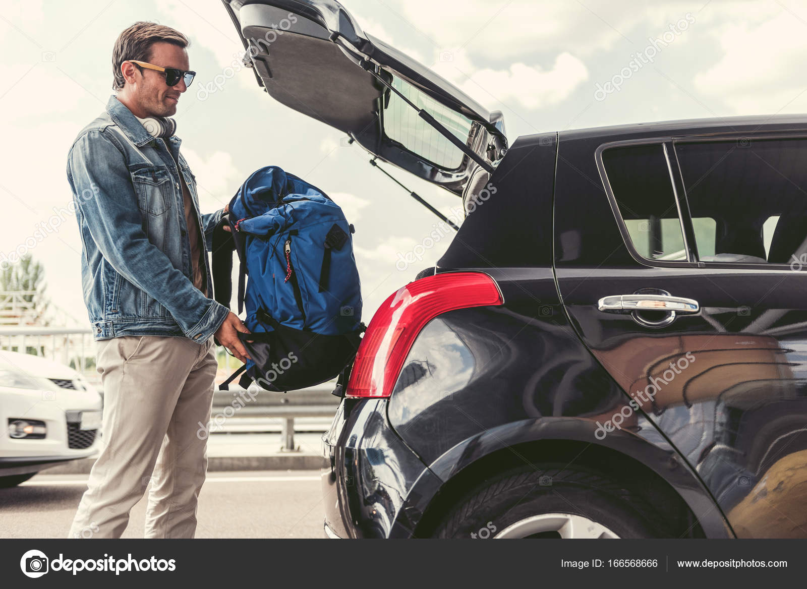 Stylish adult guy is laying down his luggage Stock Photo by ...