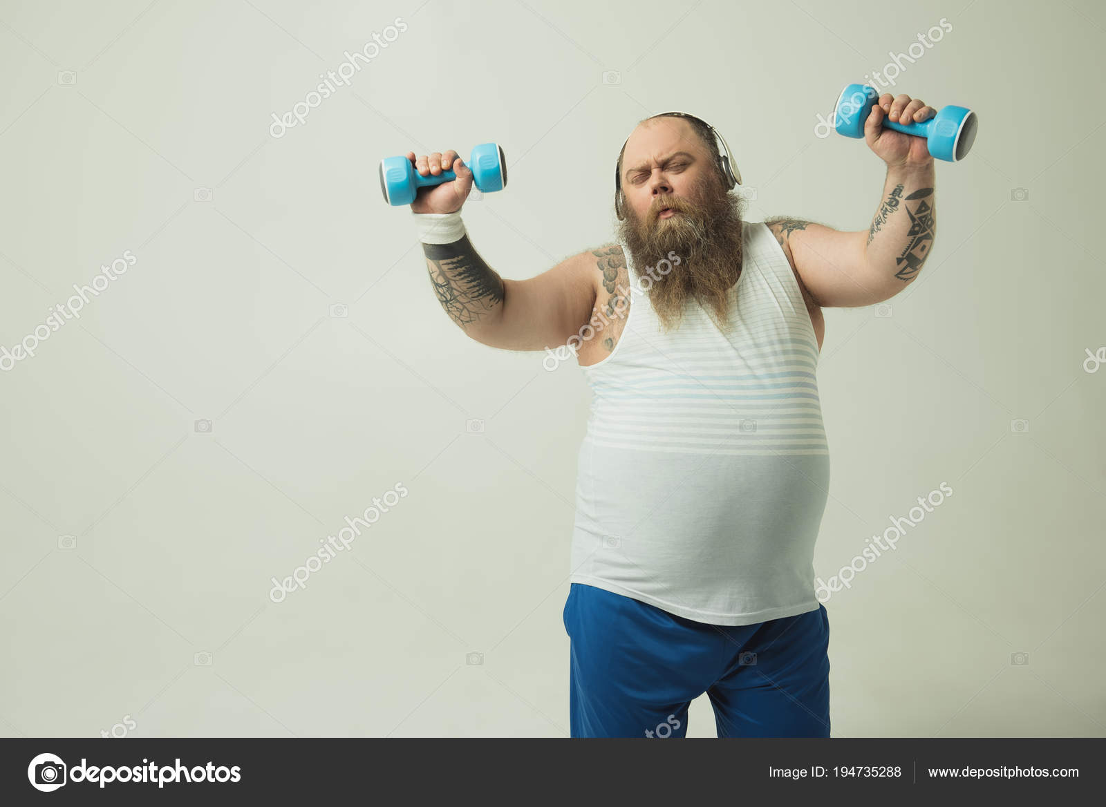 Relaxed fat man listening to music and lifting dumbbells Stock Photo by ...