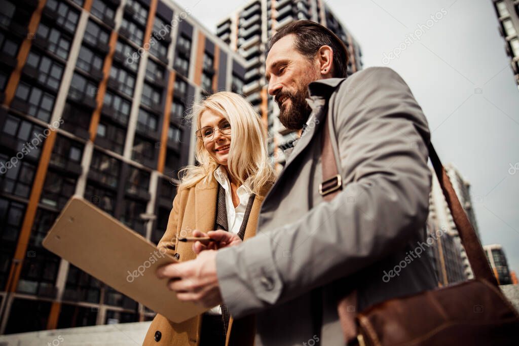 Sonriente agente de bienes raíces hablando con su cliente femenino 2024