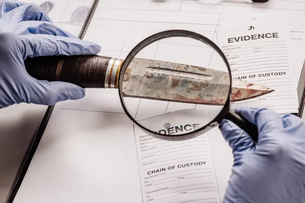 Detective through a magnifying glass looking at a evidence — Stock ...