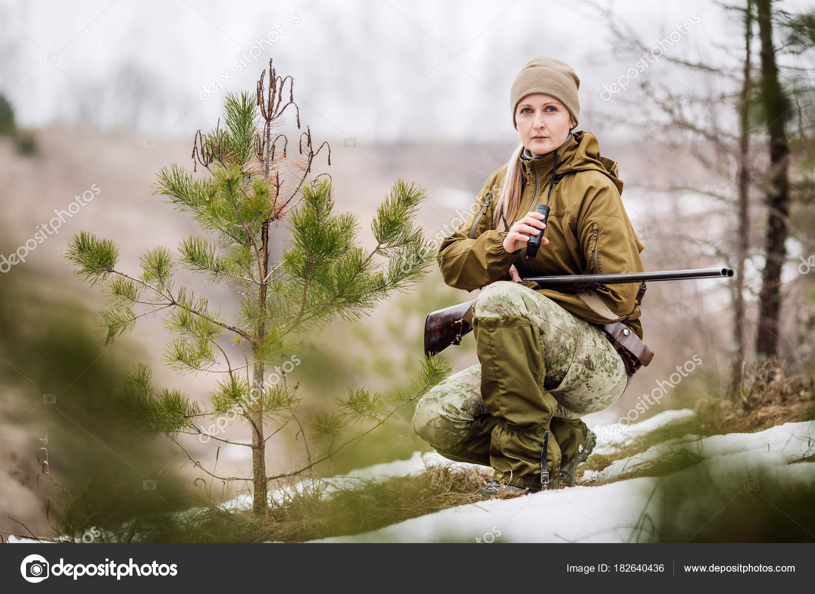 Female hunter ready to hunt, holding laser finder in forest. hun Stock ...