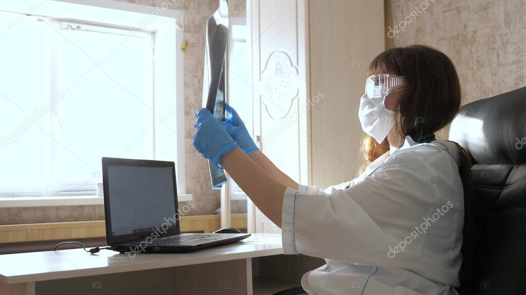 Una doctora en un consultorio examina una radiografía del paciente en el hospital. médico ...