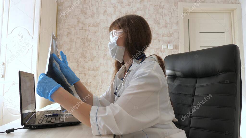 Una doctora en un consultorio examina una radiografía del paciente en el hospital. médico ...