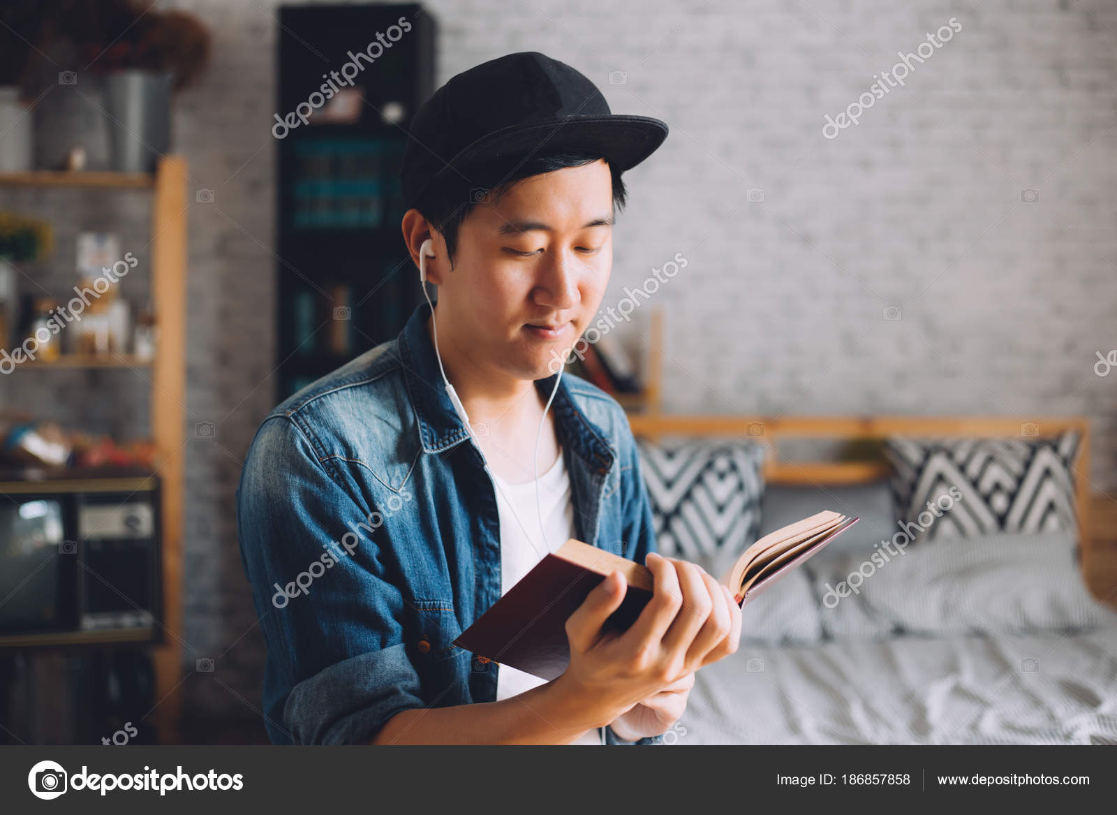 Young Asian man reading book in living cozy room — Stock Photo ...