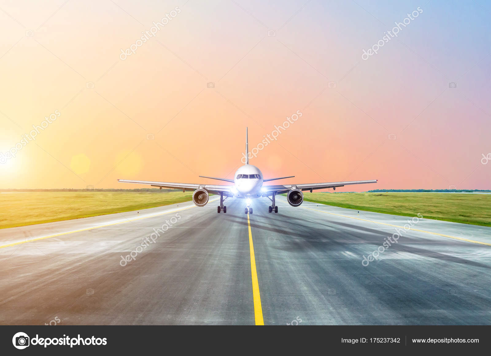 Aircraft taxiing on the runway at the airport at dusk with lights on, view of the nose of the ...