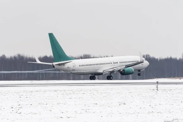 Airplane take off from the snow-covered runway airport in bad weather during a snow storm, a ...