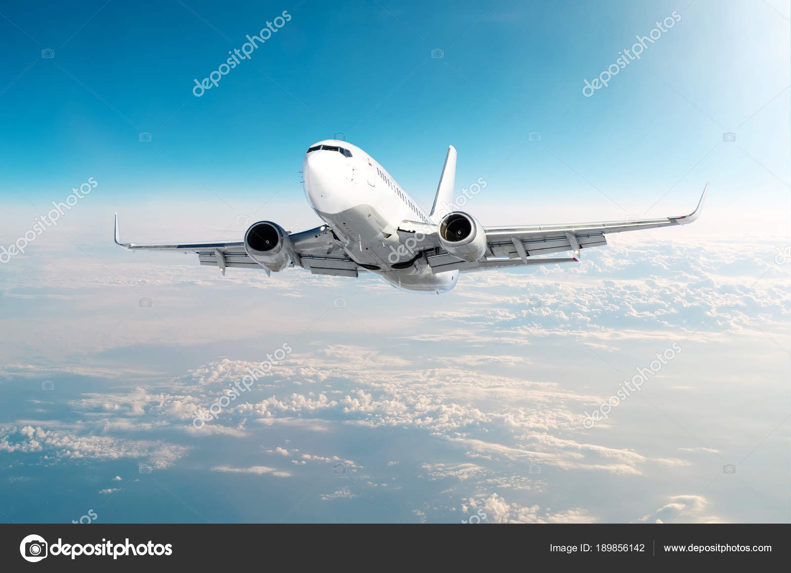 The passenger airplane is climbing high flight level in the sky above ...