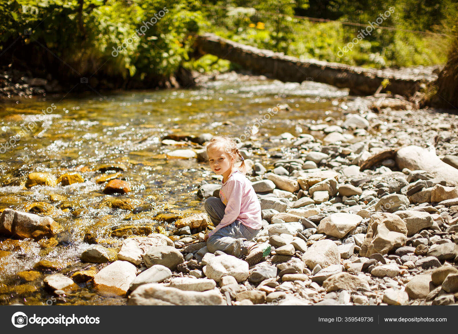 Little girl sit on rocks shore of mountain river — Stock Photo ...