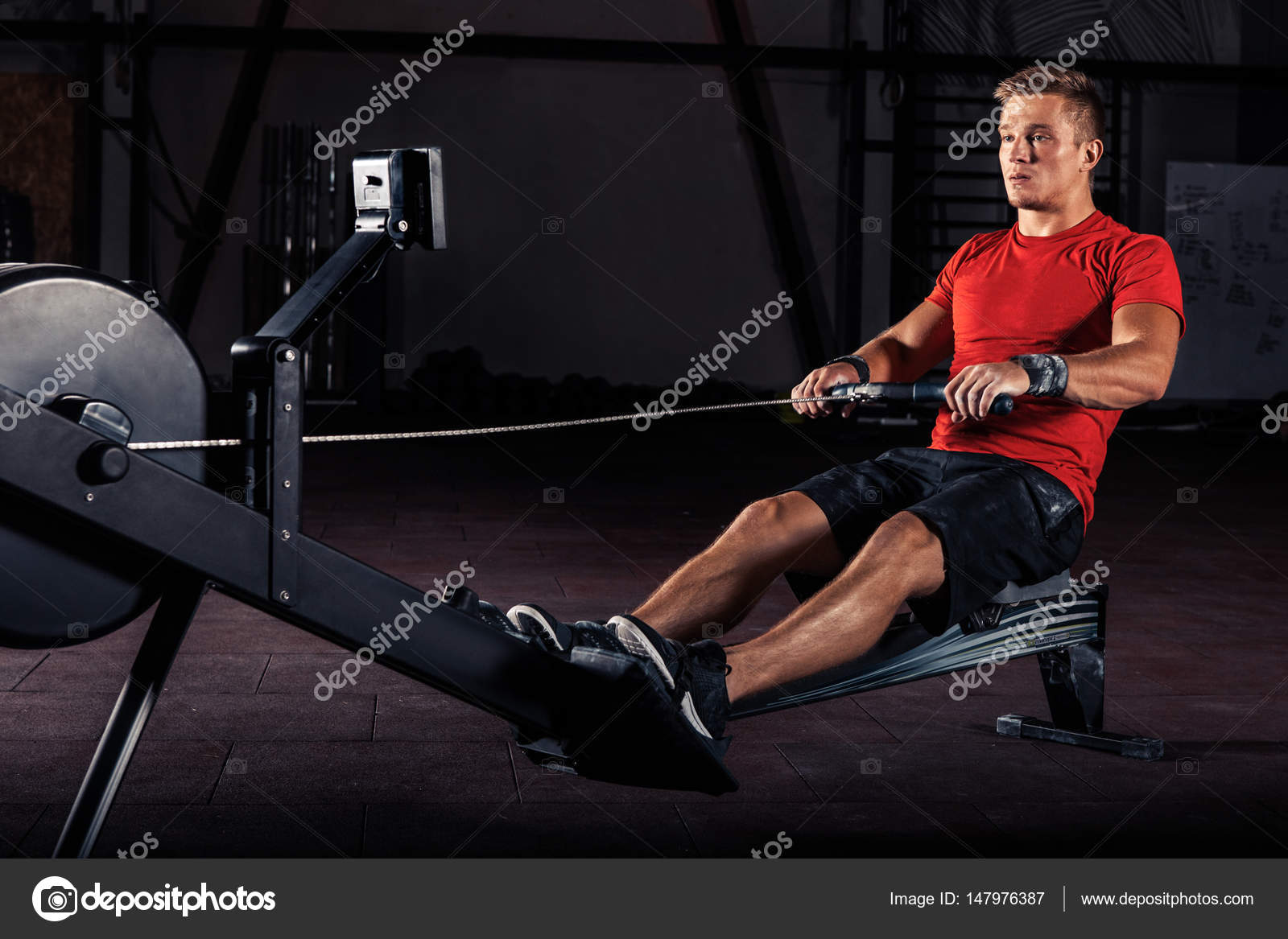 Young man using rowing machine in the gym Stock Photo by ©takoburito ...