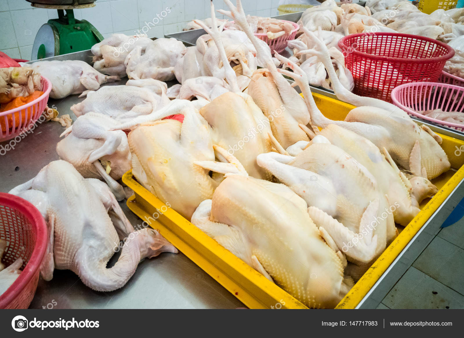 Vendor selling freshly slaughtered whole chicken in market stall ...