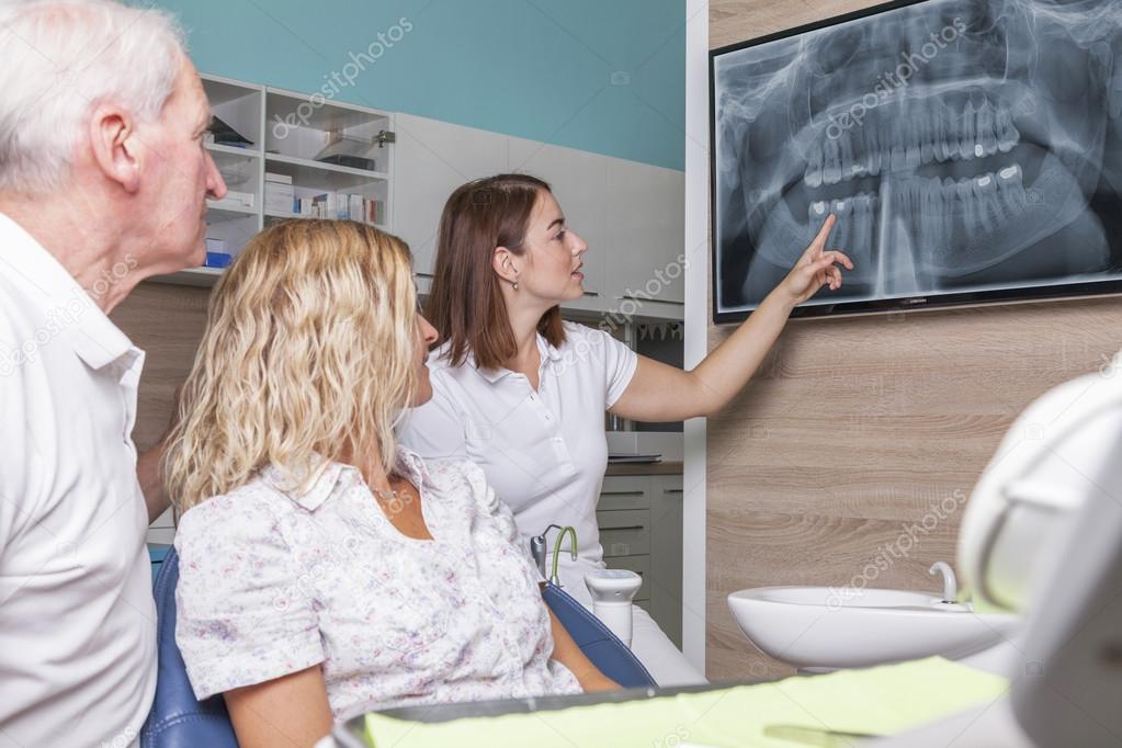 asistente dental explica el tratamiento a su paciente 2024