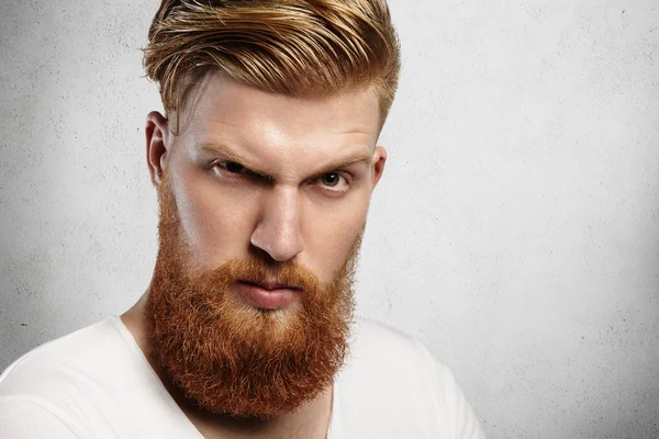 Portrait of confident macho redhead male model with severe and rough ...