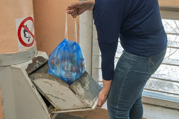 Throwing away a garbage packed in a garbage bag using a home garbage ...