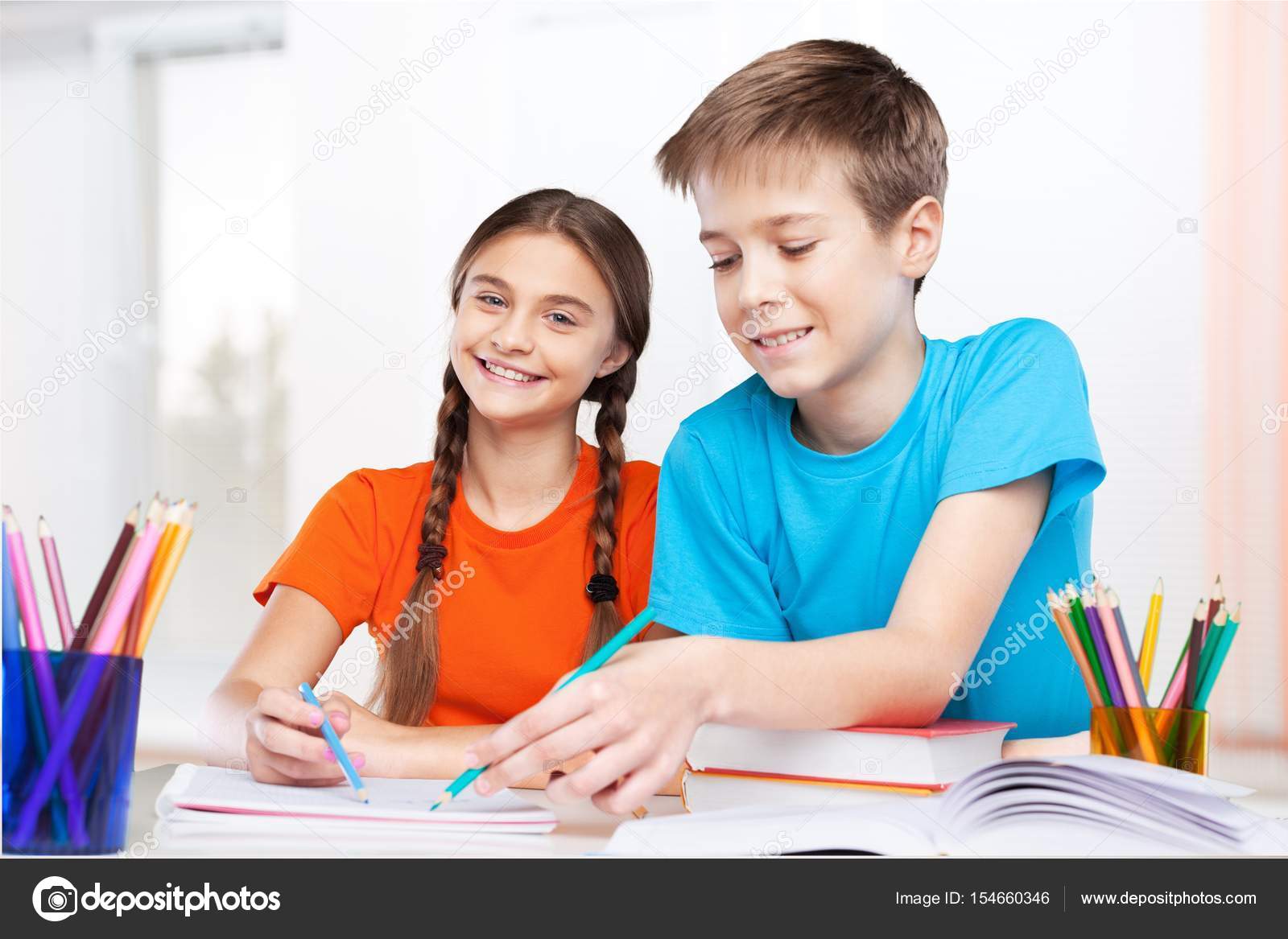 Children sitting by the table during lesson Stock Photo by ...