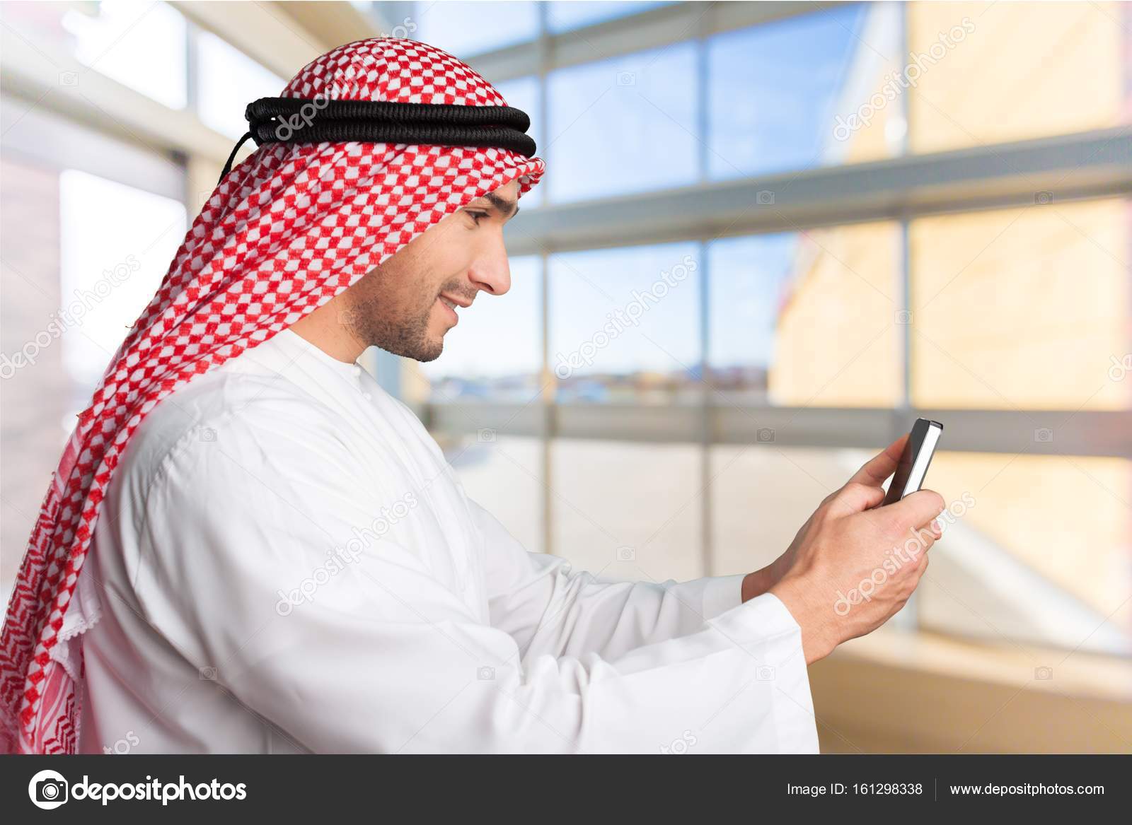 Handsome arab man using smartphone — Stock Photo © billiondigital ...