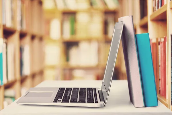 Stack of books with laptop Stock Photo by ©billiondigital 118714404