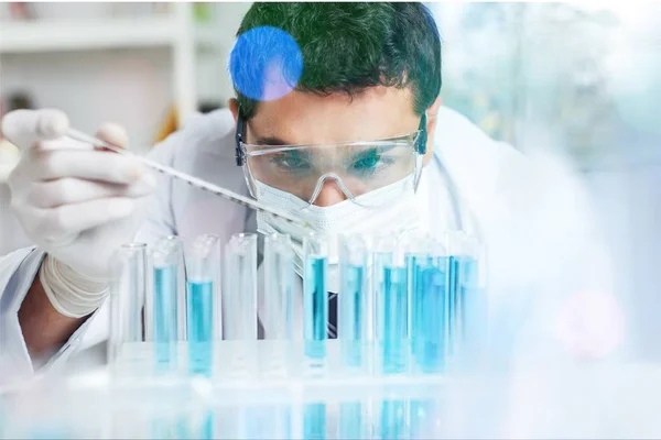 Portrait of concentrated male scientist working with reagents in ...