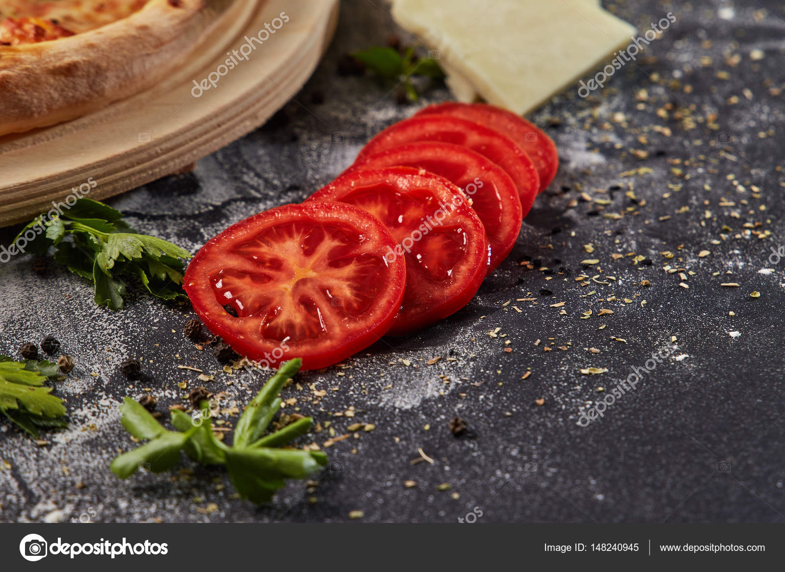 Whole and cutted tomato of pizza on italian black paper table Stock ...