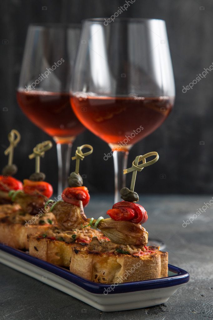 Spanish tapa pinxtos with tuna, peper, onion and oregano. Wine on ...