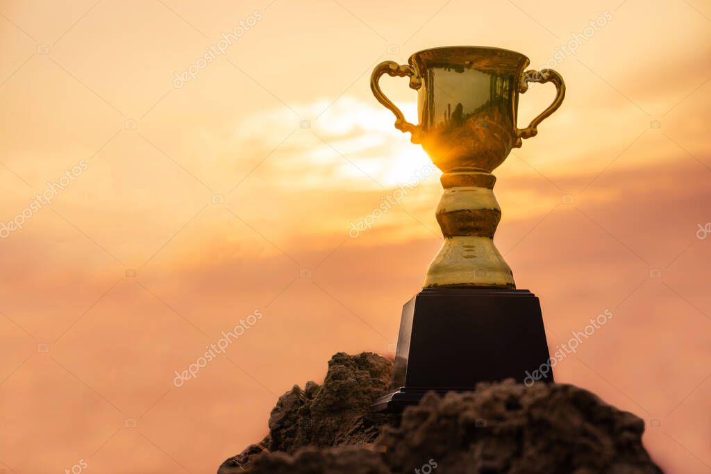Concepto de victoria, copa de trofeo de oro en la cima de la montaña ...