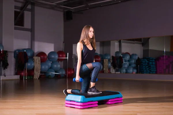 Sporty woman using step platform - Stock Image - Everypixel