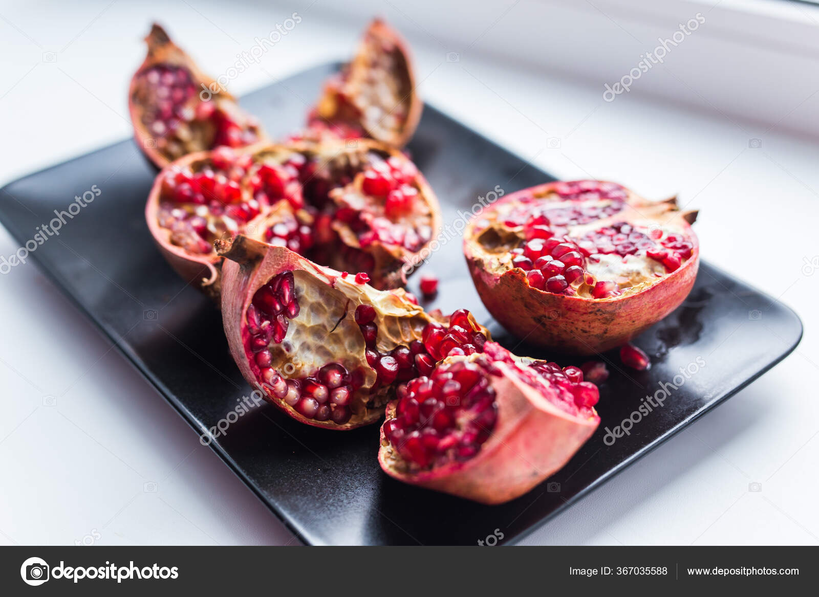 Big ripe red garnet. Fruits of red ripe pomegranate on the windows sill ...