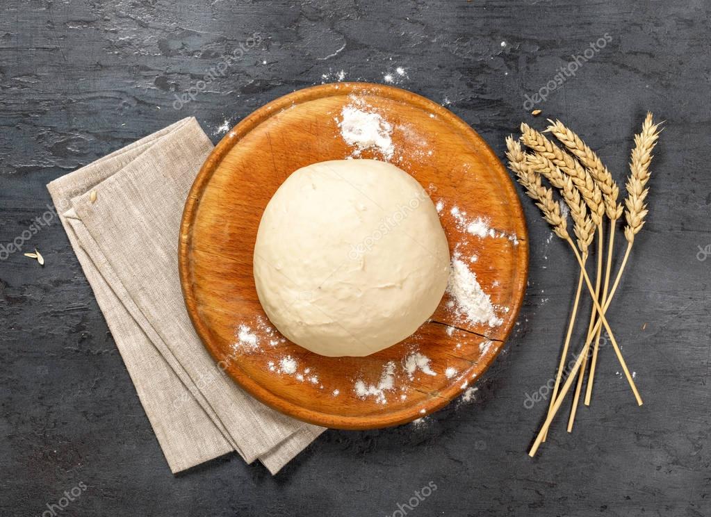 Masa fresca sobre tabla redonda de madera con espigas de trigo 2023