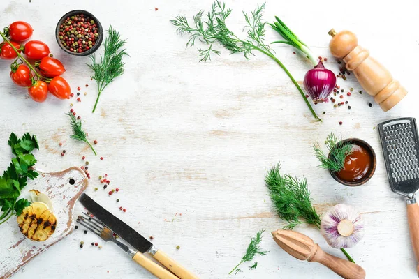 White kitchen background. Kitchen board, vegetables and spices on a ...