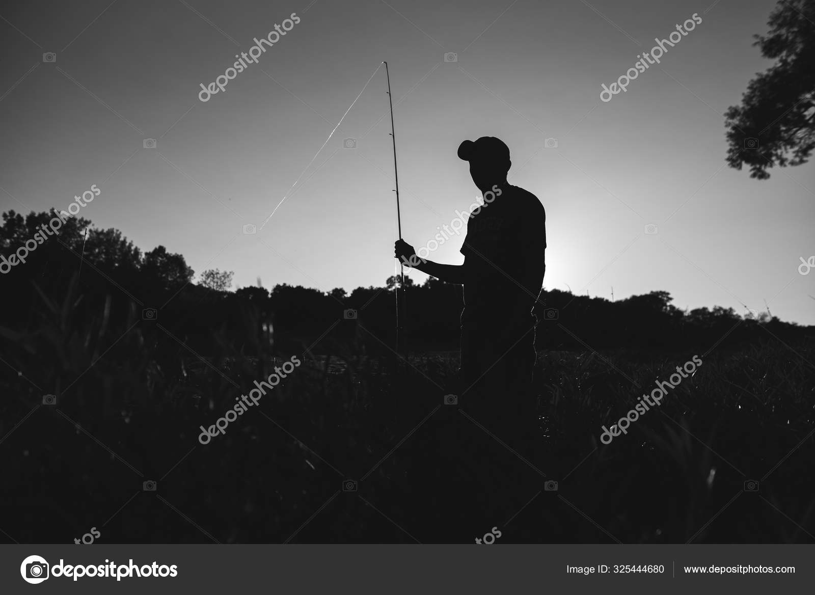 A fisher stands at his fishing spot on the White River in Indianapolis ...