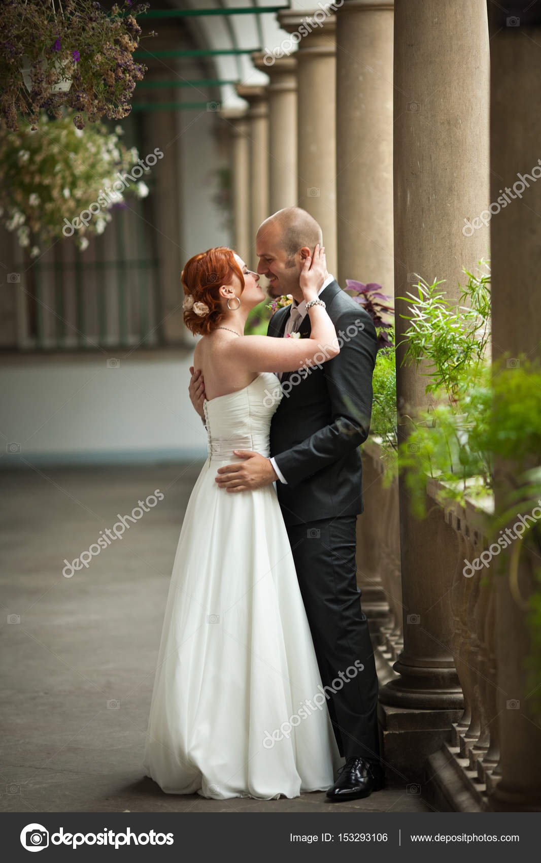 Bride looks over her shoulder while groom waits for her Stock Photo by ...