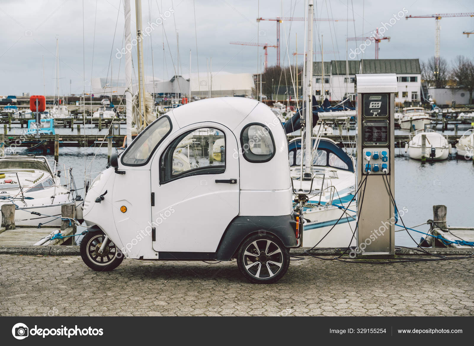 Small electro car charging in street seafront in Copenhagen, Denmark ...