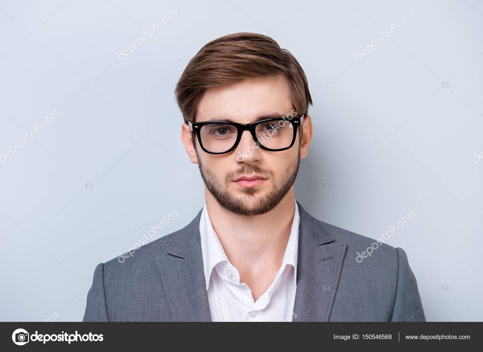 Portrait Of Serious Young Man In Glasses Looking Straight In Cam Stock