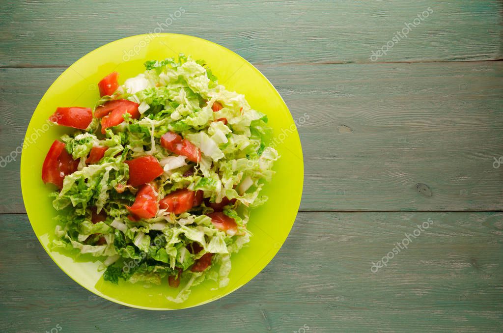 ensalada de tomate de col en un plato sobre un fondo de madera 2022