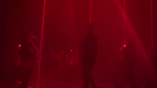 People looking at laser light installation with changing color and ...