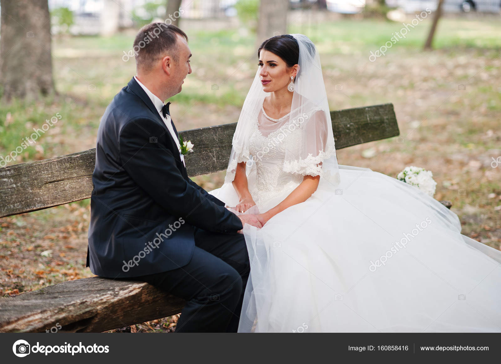Fantastic wedding couple sitting on the bench in the park on the — Stock Photo © ASphoto777 ...