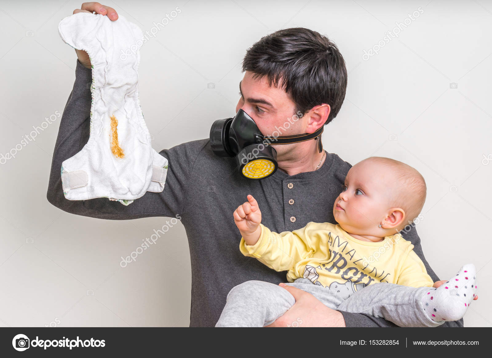 Father with gas mask is holding dirty diaper and little baby — Stock ...