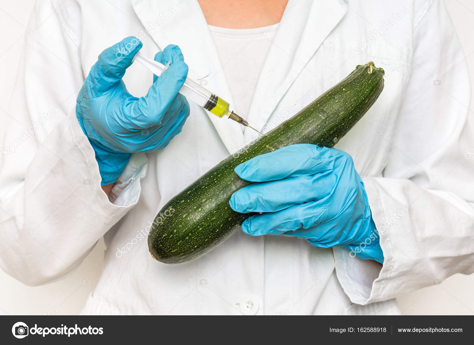 GMO scientist injecting liquid from syringe into zucchini Stock Photo ...